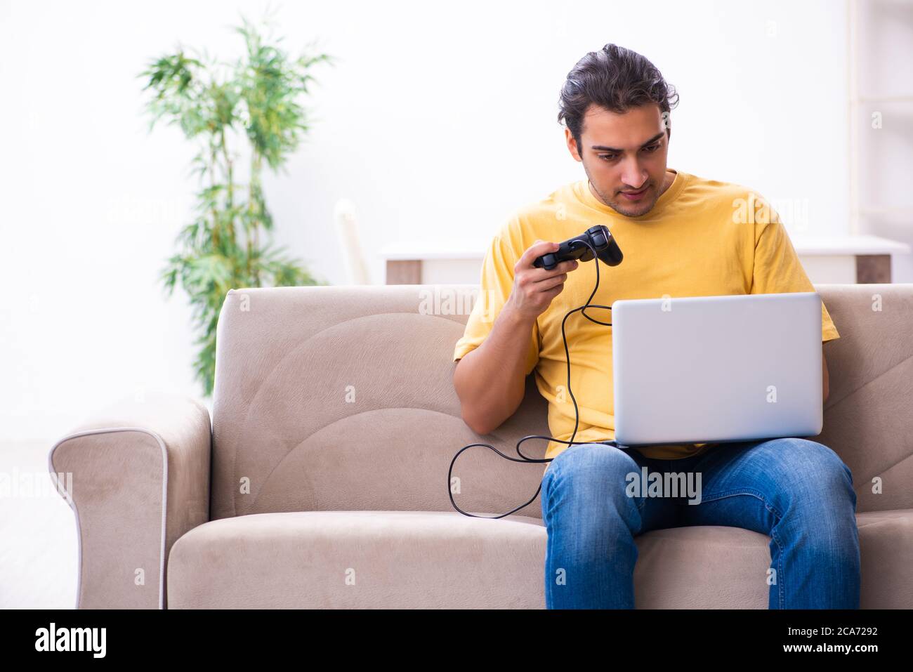 Young man playing joystick games at the home Stock Photo - Alamy