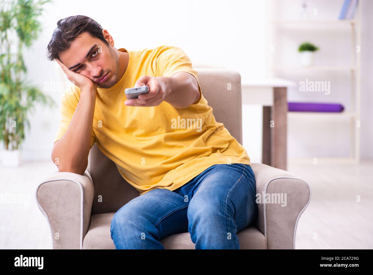 Young man watching tv at the home Stock Photo - Alamy