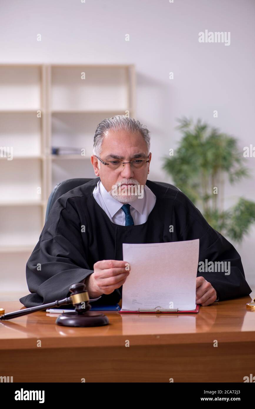 Old male judge working in the courthouse Stock Photo - Alamy