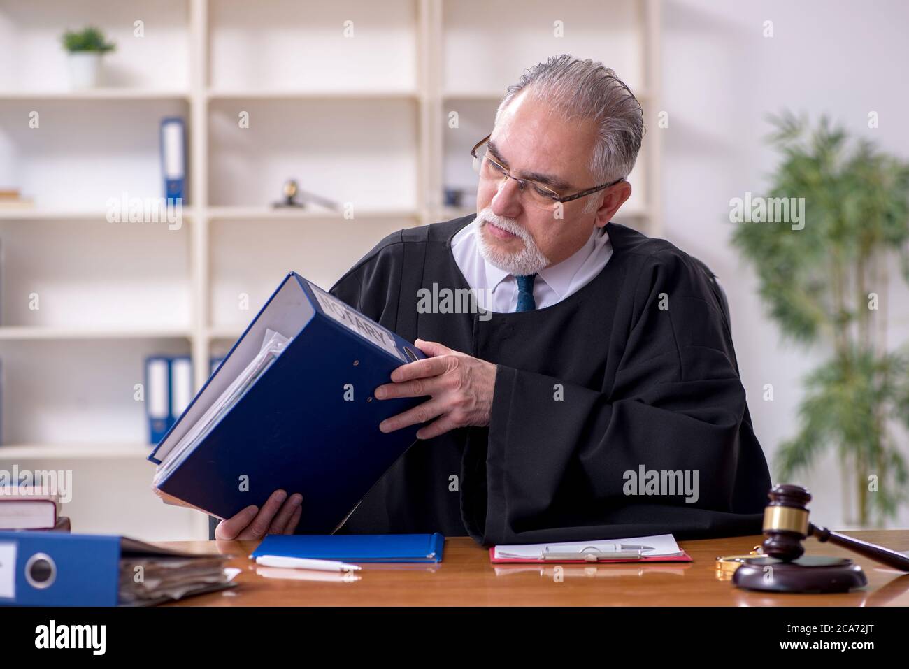Old male judge working in the courthouse Stock Photo - Alamy