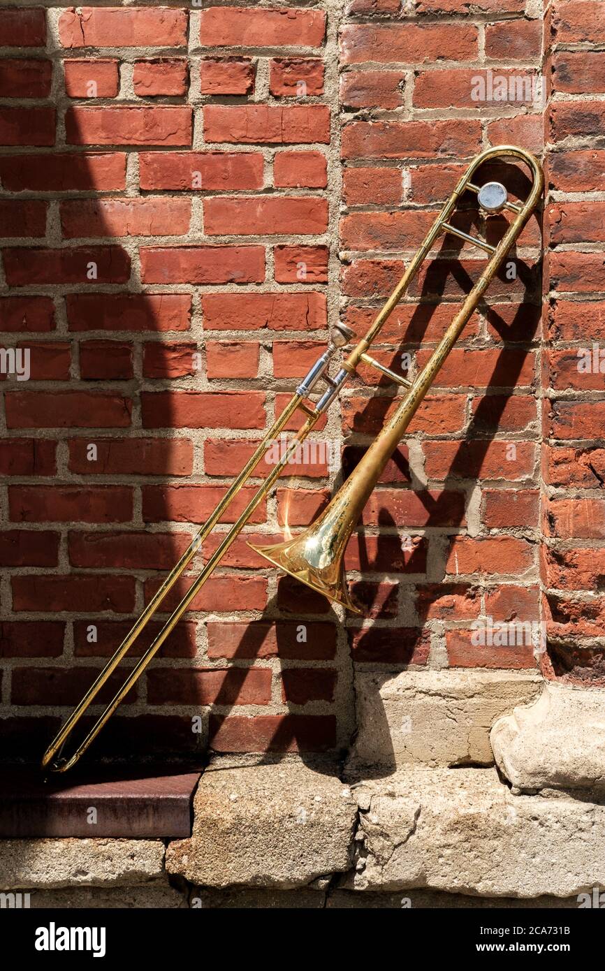 Old rusty vintage trombone leans against brick building outside jazz ...