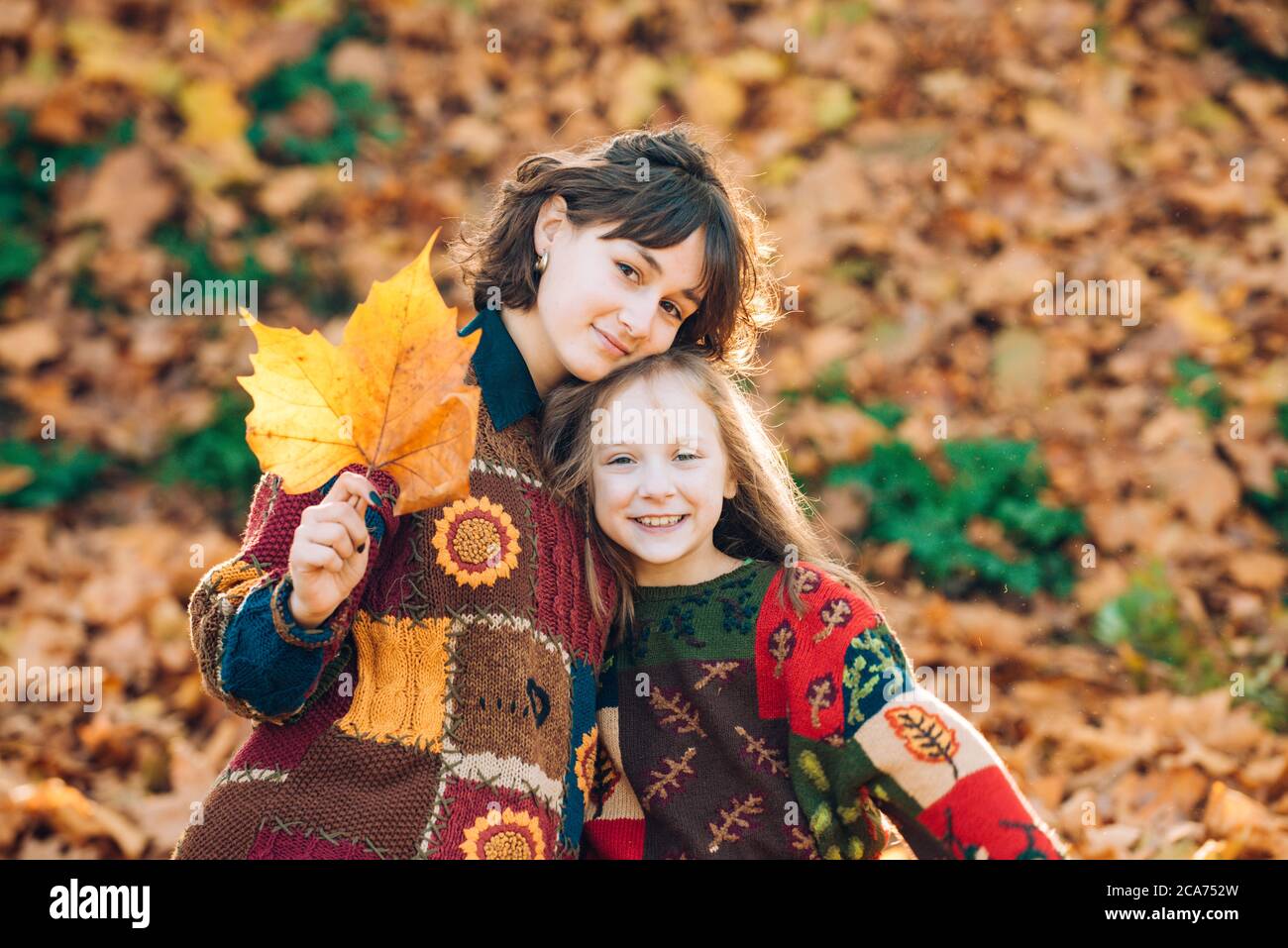 Sisters portrait in forest in fall colors. Beautiful sister standing in ...