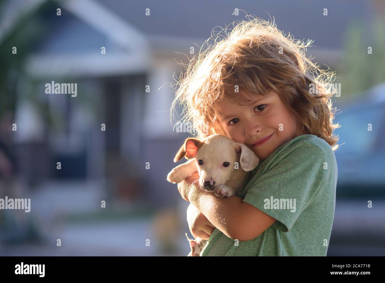 Child lovingly embraces his pet dog. Cute kids boy enjoying with her ...