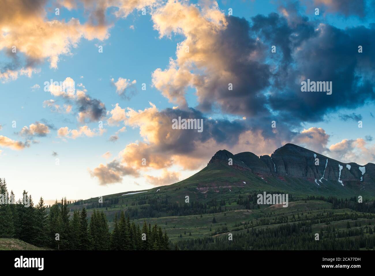 Dramatic, colorful clouds at sunset over a snow-capped peak in Colorado ...