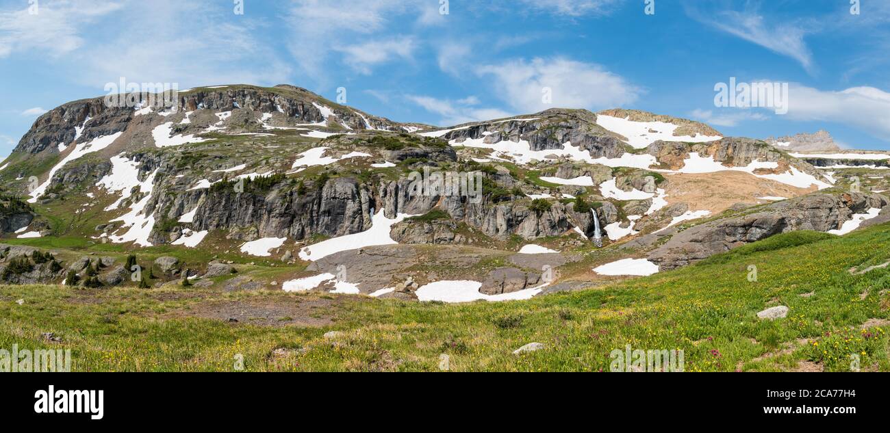 Panoramic alpine scene with snow-capped mountains, a waterfall, and an ...
