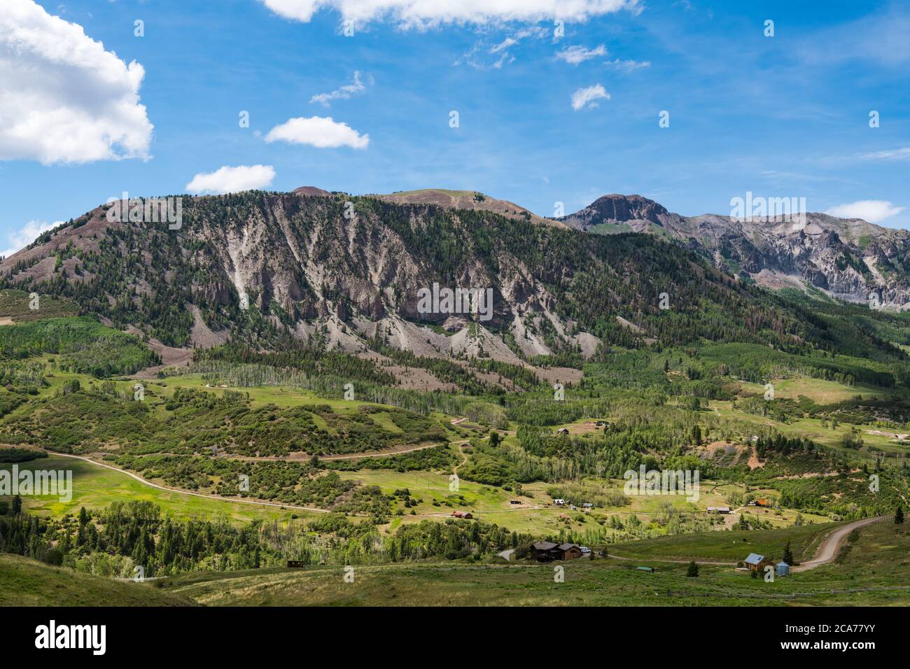 View of Last Dollar Road winding through a vast landscape of mountains ...