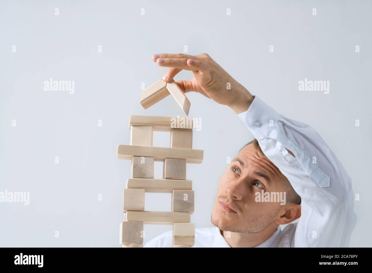 Businessman making tower Stock Photo - Alamy
