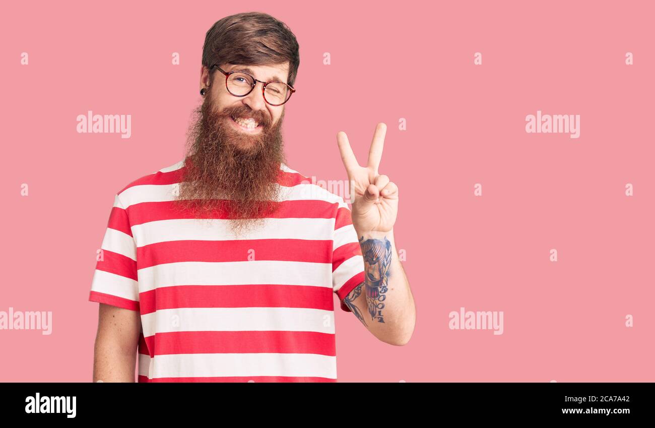 Handsome young red head man with long beard wearing casual clothes ...