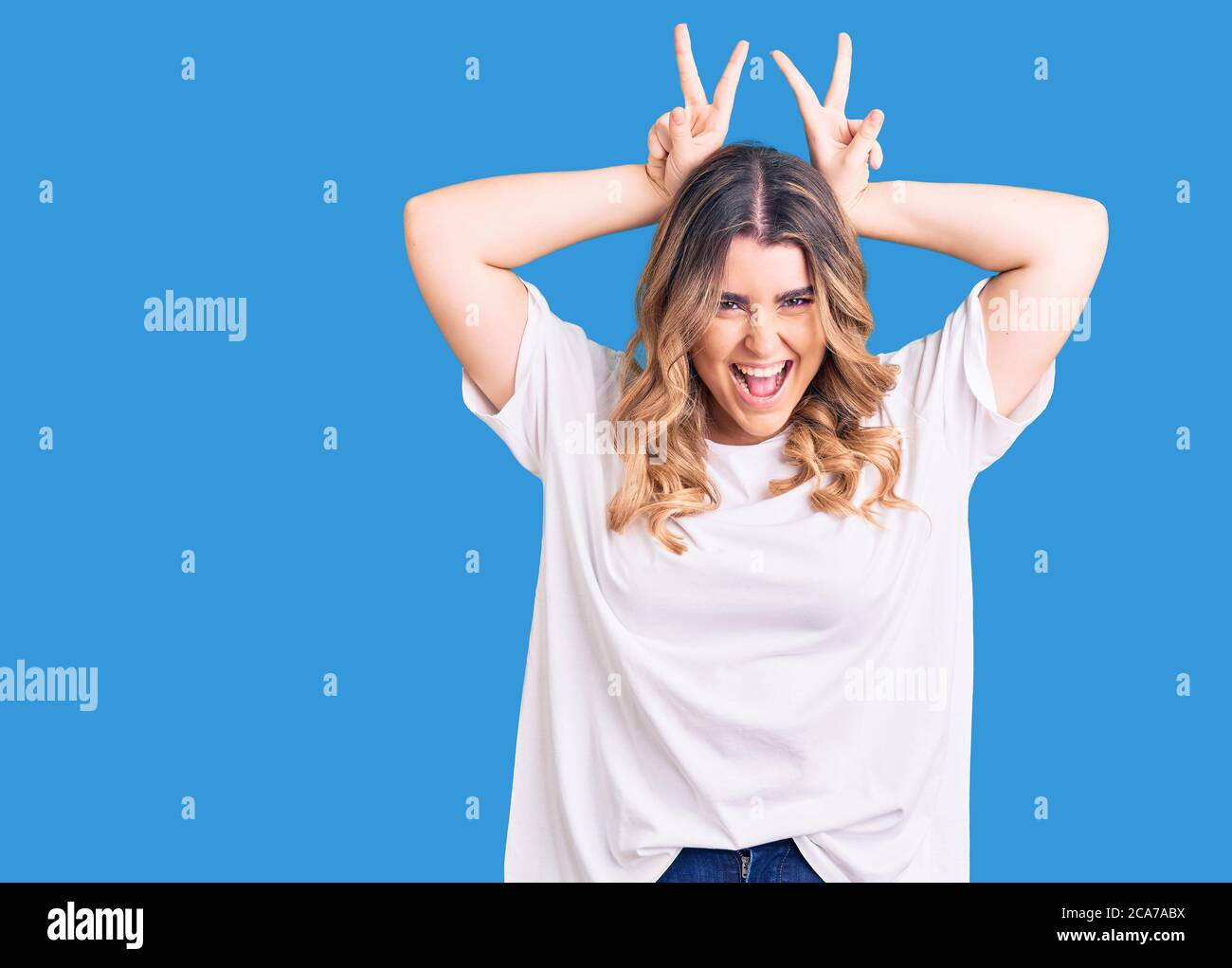 Young caucasian woman wearing casual clothes posing funny and crazy ...
