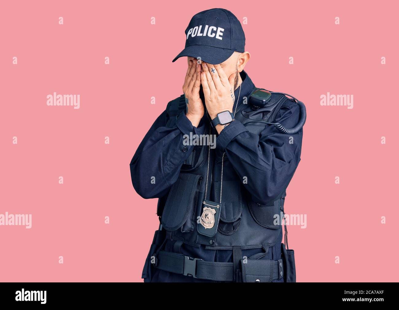 Young handsome man wearing police uniform rubbing eyes for fatigue and ...
