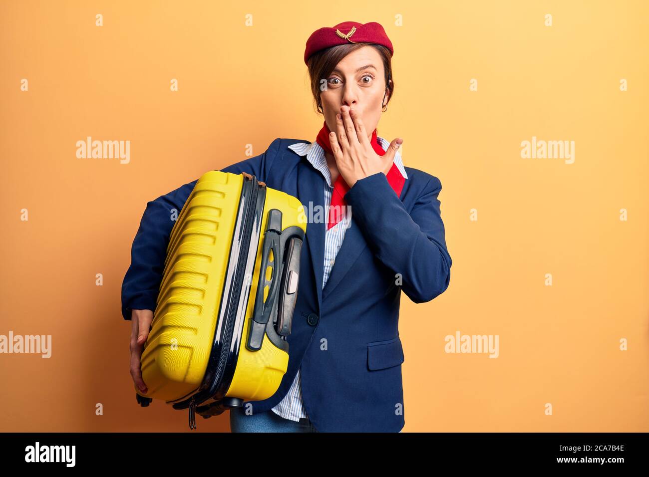 Young beautiful woman wearing stewardess uniform holding cabin bag ...