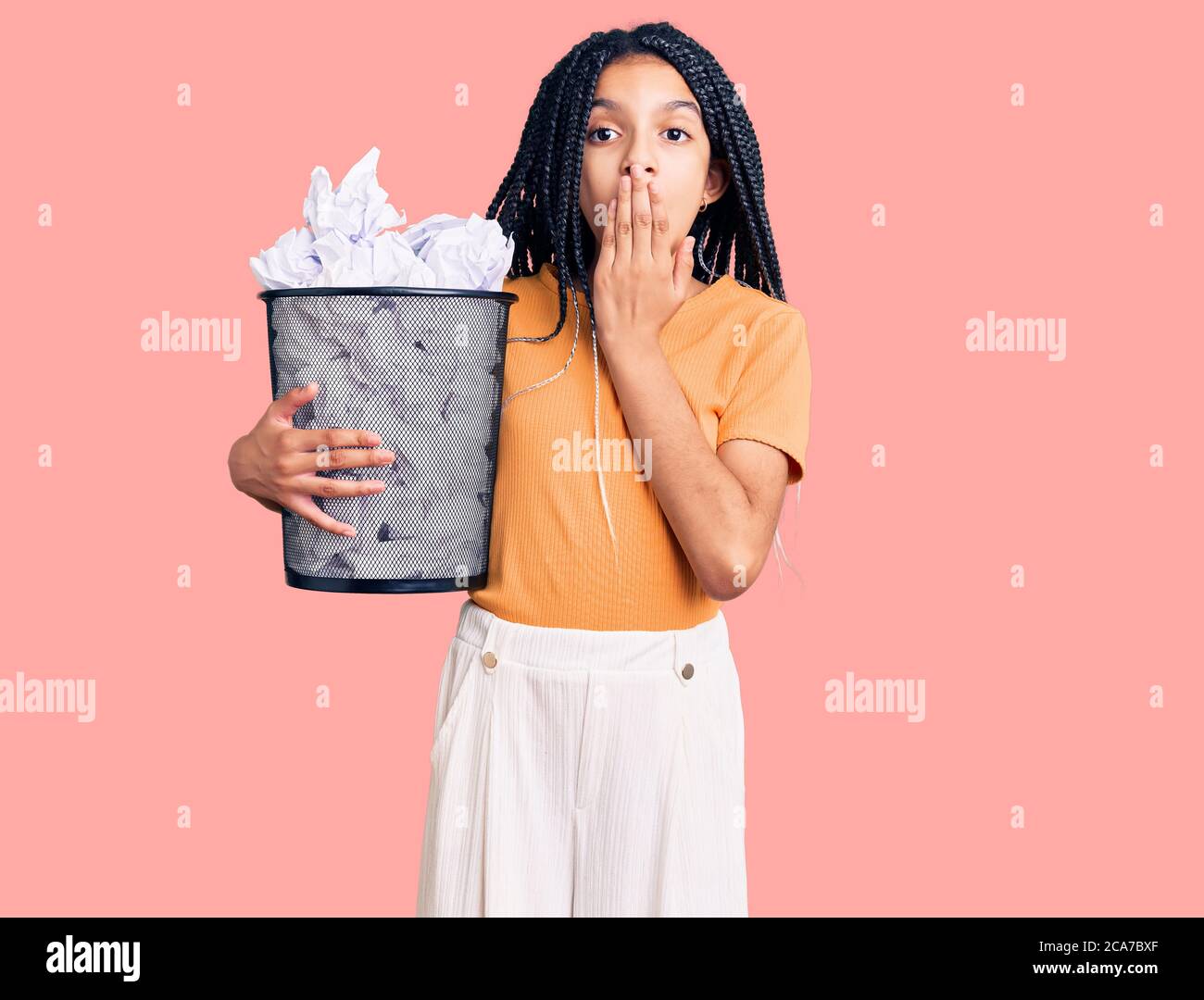Cute african american girl holding paper bin full of crumpled papers ...