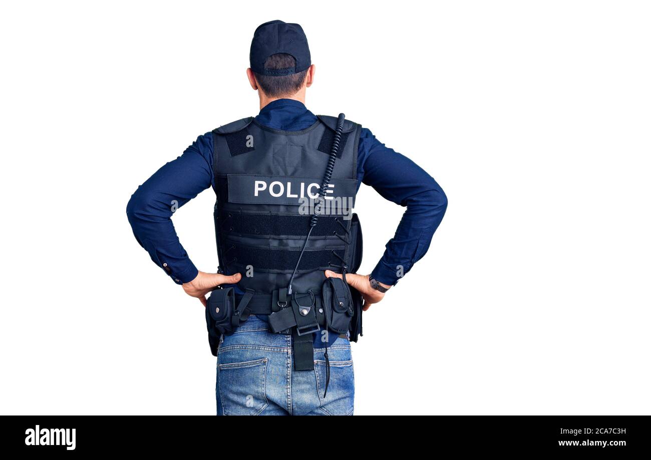 Young handsome man wearing police uniform standing backwards looking ...