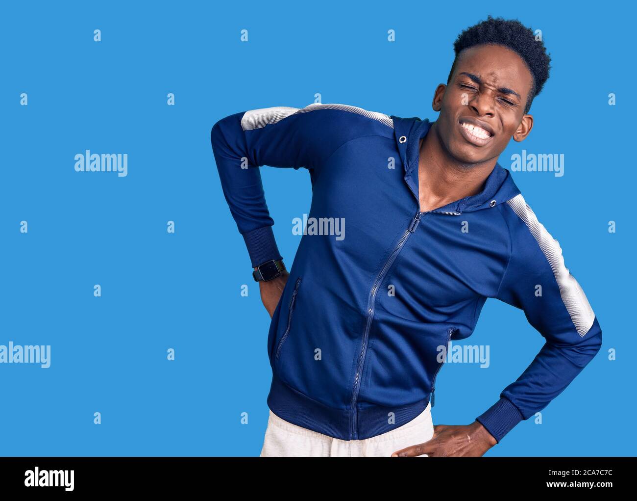 Young african american man wearing sportswear suffering of backache ...