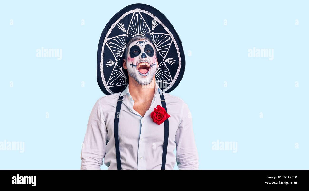 Man wearing day of the dead costume over background angry and mad ...