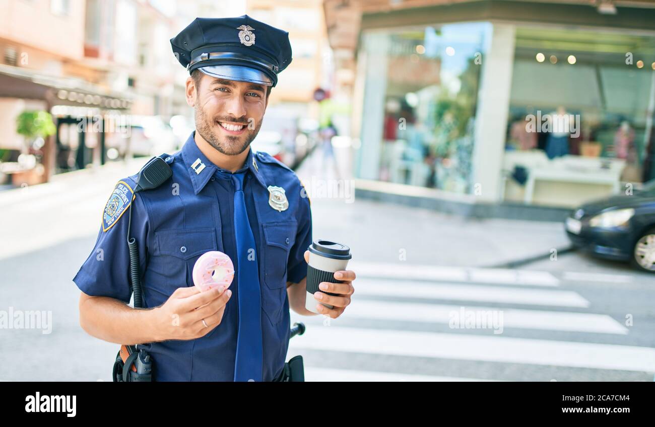 Young handsome hispanic policeman wearing police uniform smiling happy ...