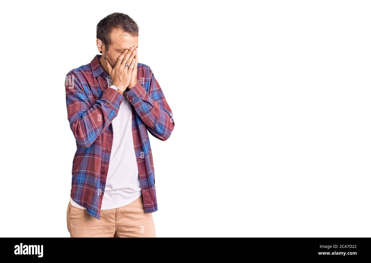 Young handsome man wearing casual clothes with sad expression covering ...