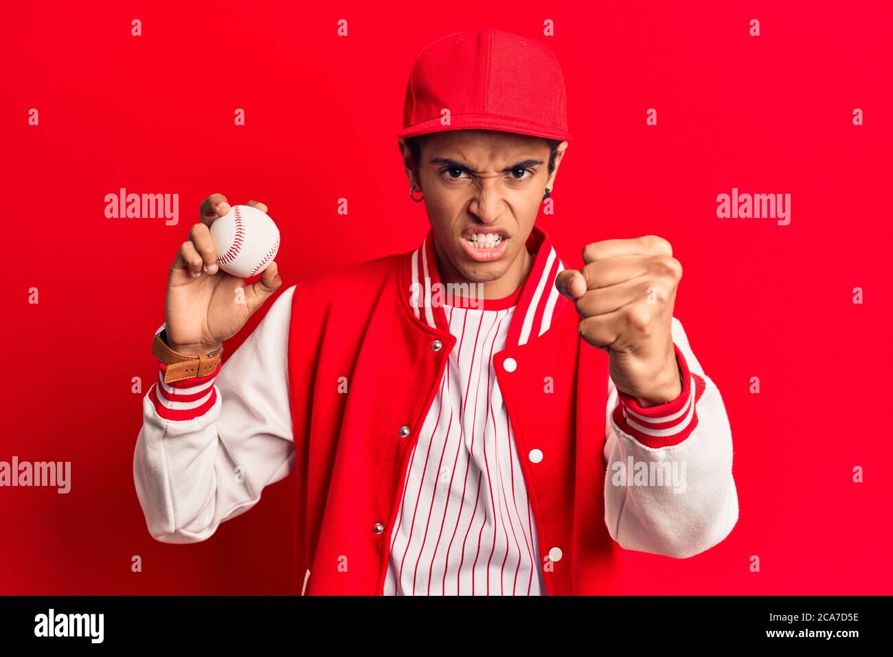 Young african amercian man wearing baseball uniform holding ball ...