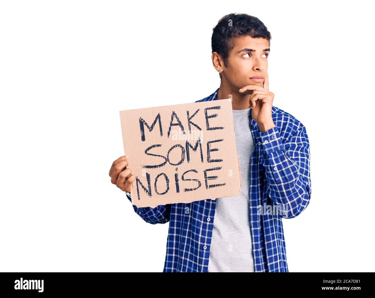 Young african amercian man holding make some noise banner serious face ...
