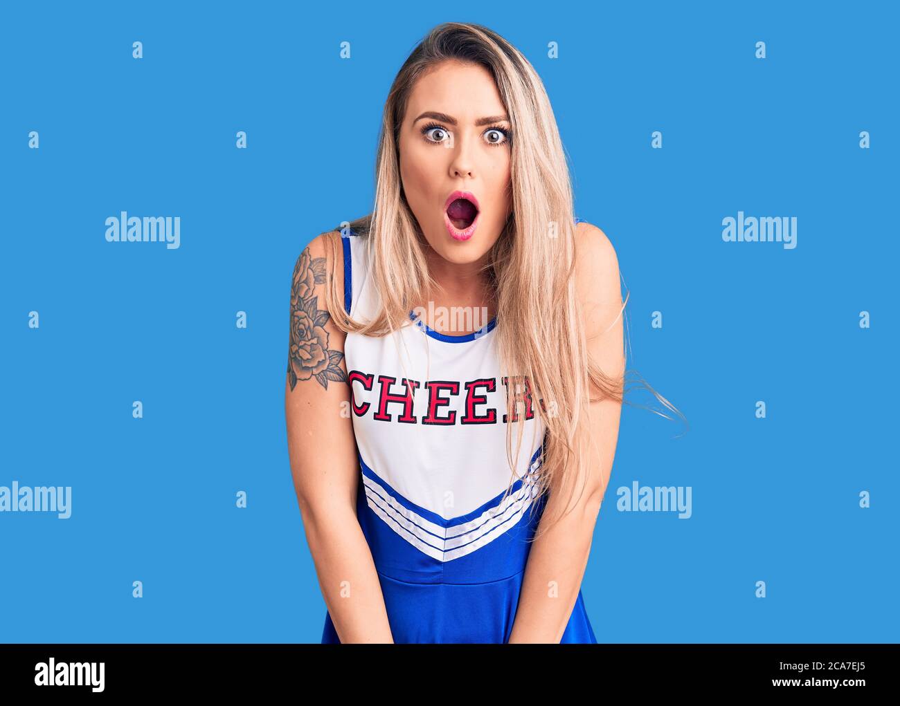 Young Beautiful Blonde Woman Wearing Cheerleader Uniform Afraid And