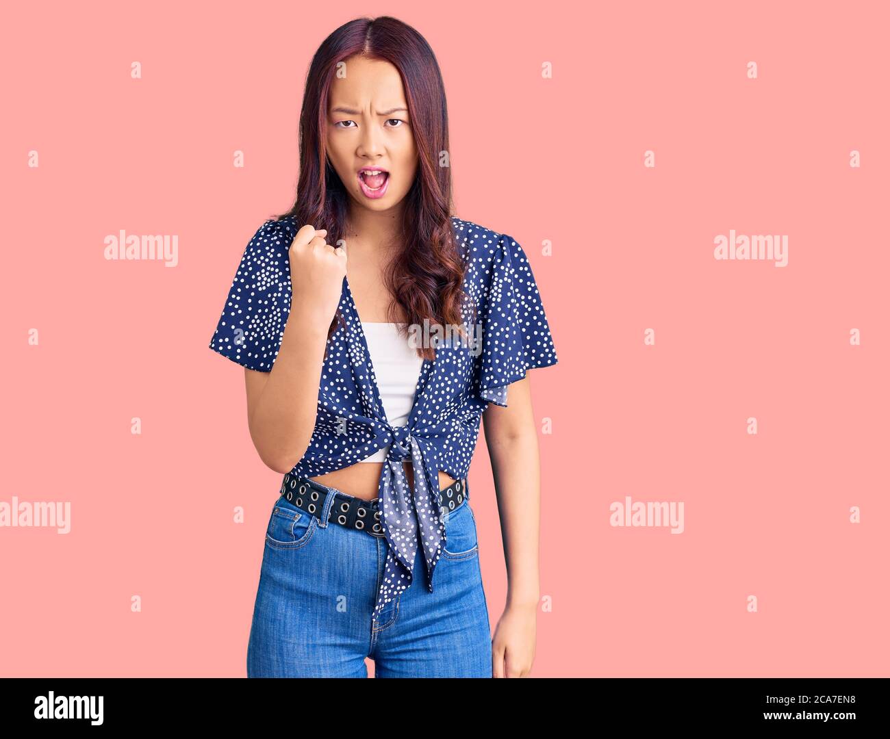 Young beautiful chinese girl wearing casual clothes angry and mad ...