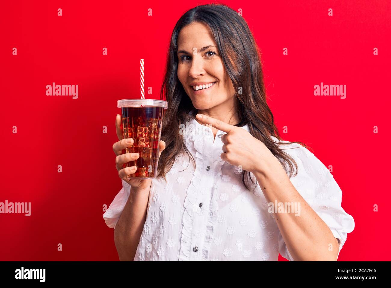 Beautiful brunette woman drinking cola refreshment beverage using straw ...