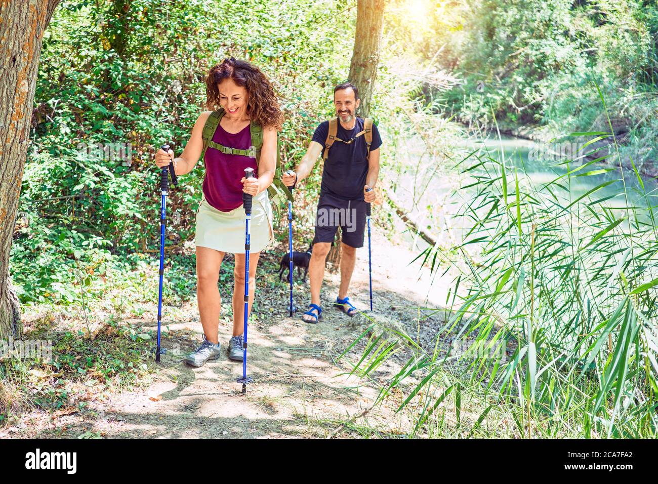 Beautiful couple of hiker wearing backpack smiling happy. Standing with ...
