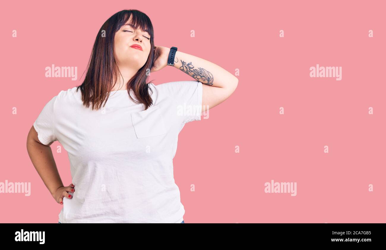 Young plus size woman wearing casual clothes suffering of neck ache ...