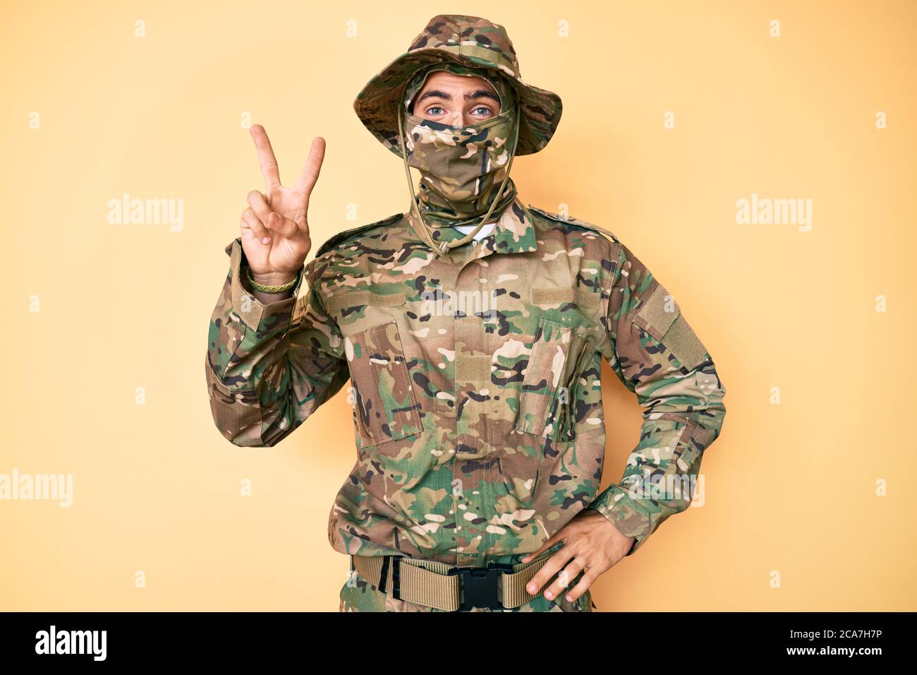 Young handsome man wearing camouflage army uniform and balaclava ...