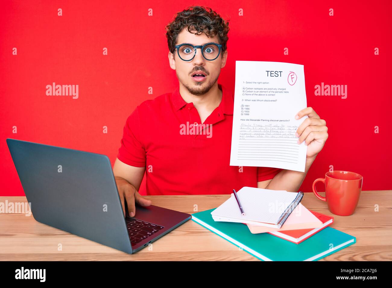 Young caucasian man with curly hair sitting on the table showing failed ...
