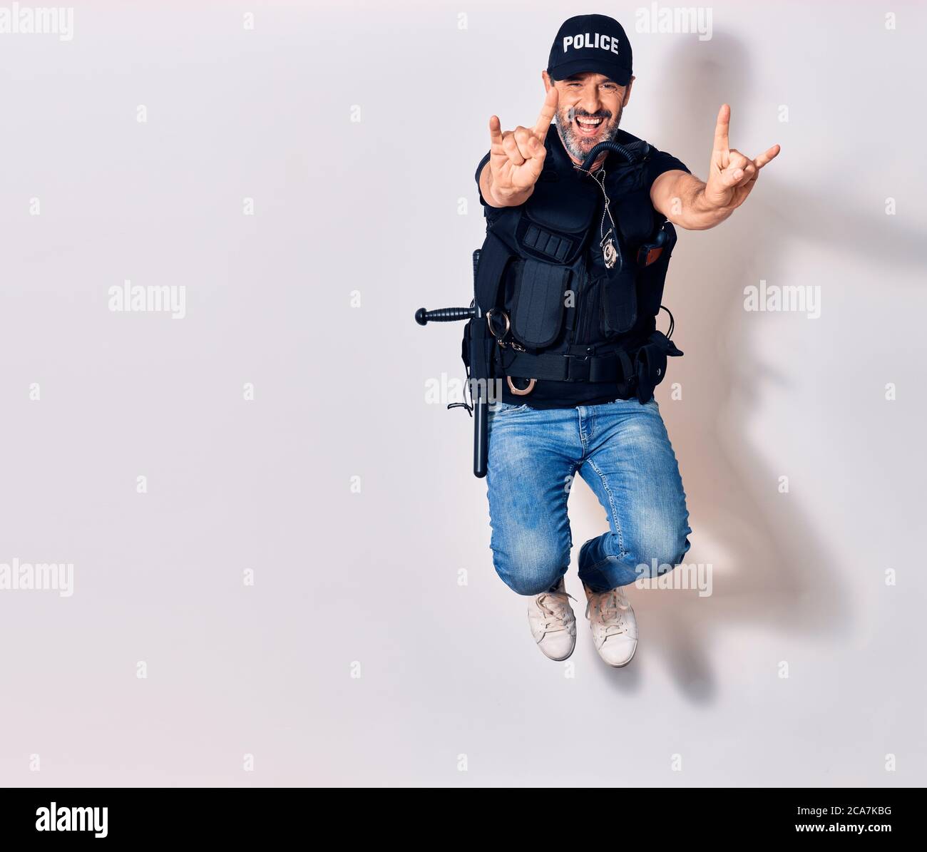 Middle age handsome man wearing police unifrom smiling happy. Jumping ...