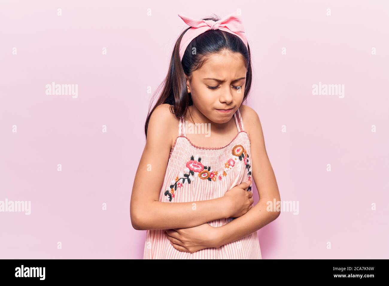 Beautiful child girl wearing casual clothes with hand on stomach ...