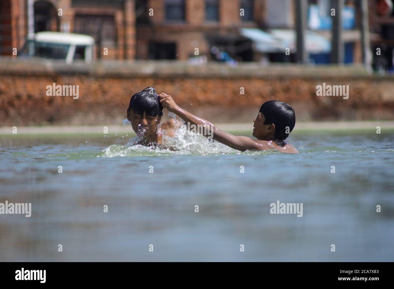 Bhaktapur, Nepal. 04th Aug, 2020. A Nepalese kid swim in a water pond ...