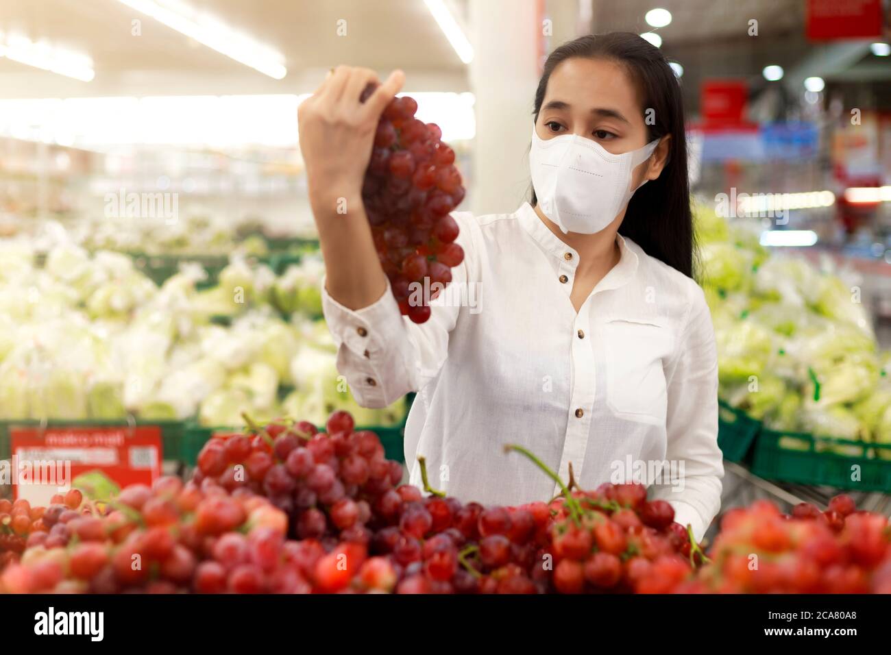 Asian woman long hair wearing protective face mask in supermarket ...