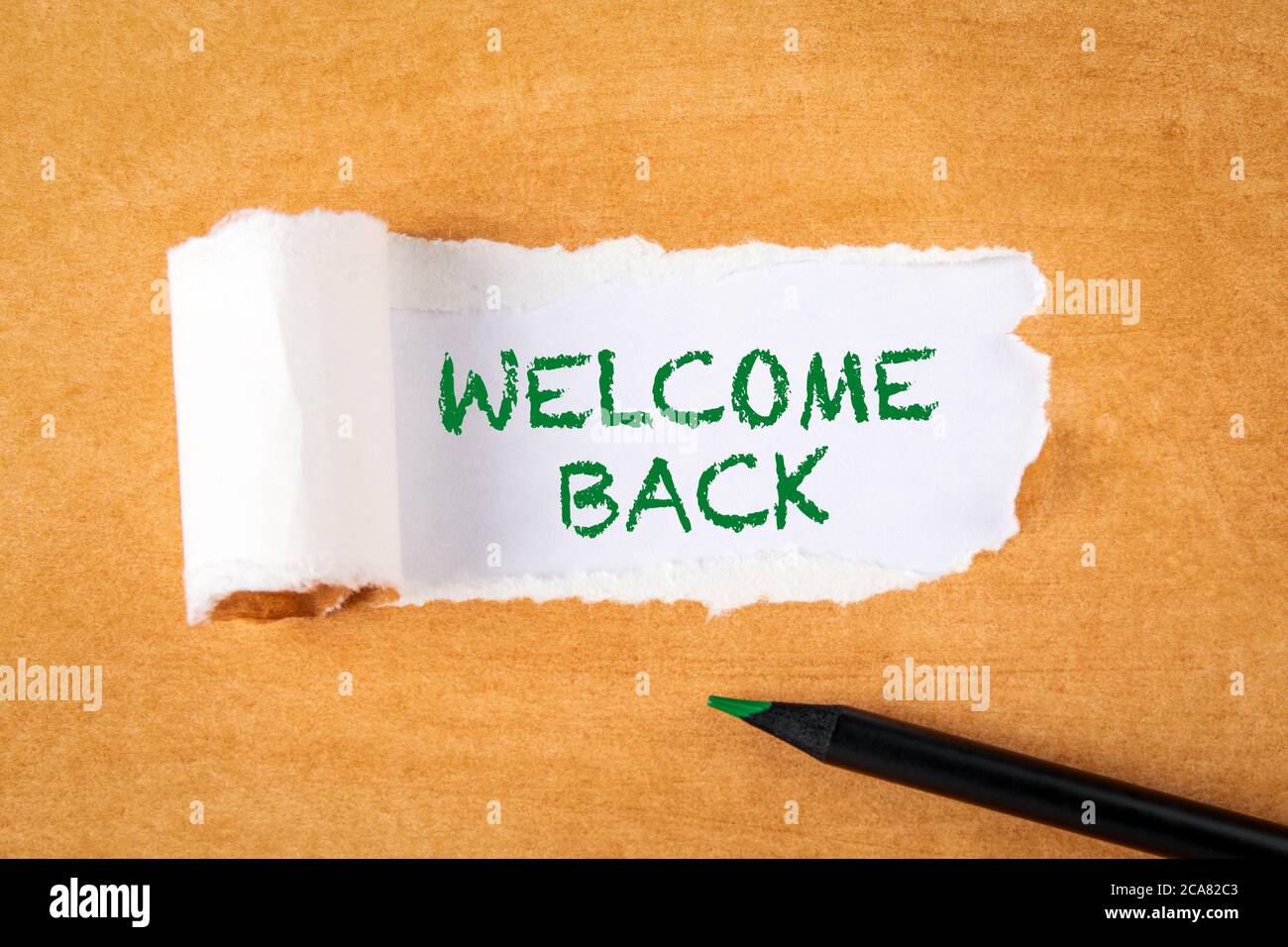 Welcome back. Text under torn paper. Green pencil Stock Photo - Alamy