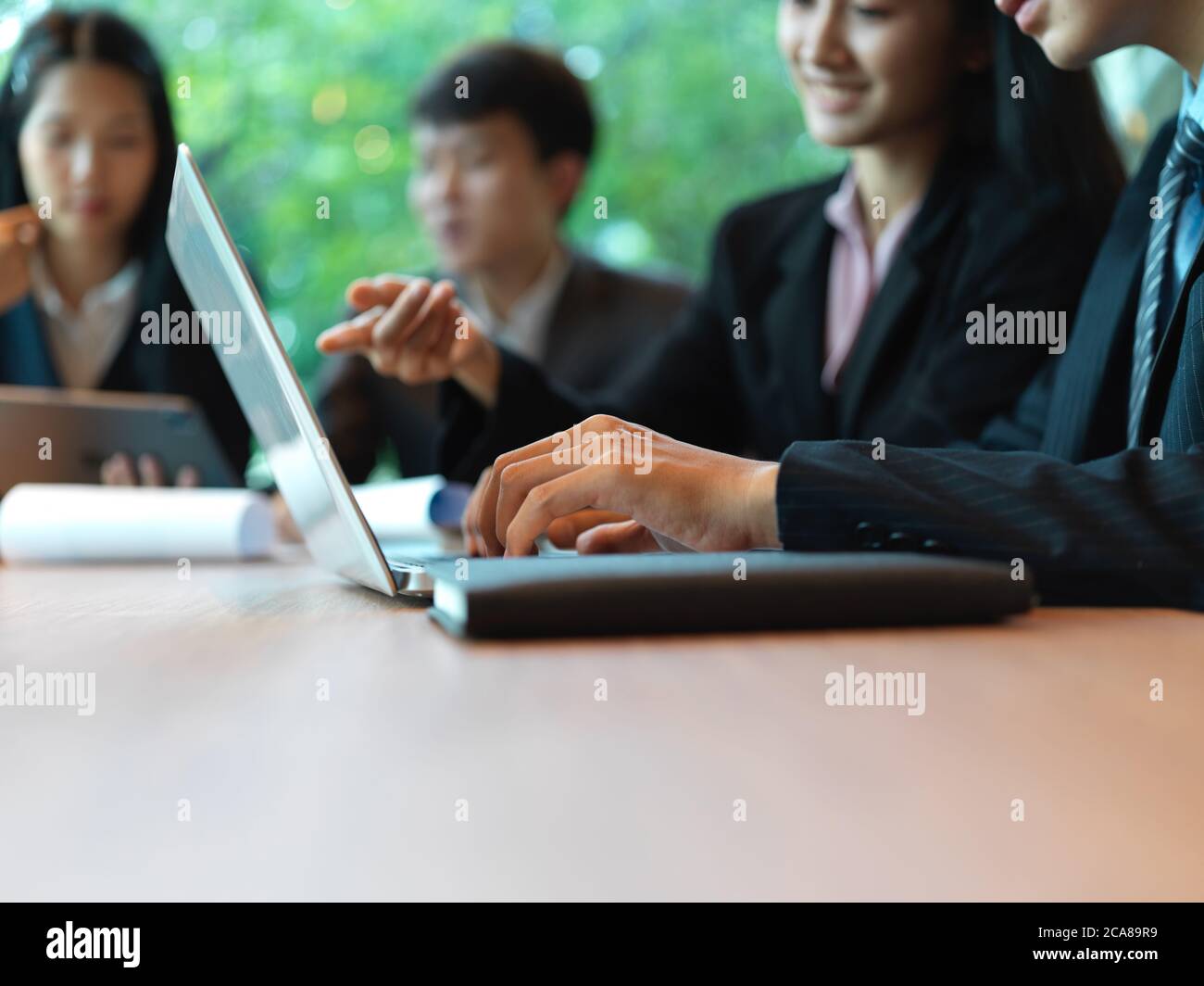 Side view of office workers consulting on their work with laptop on ...