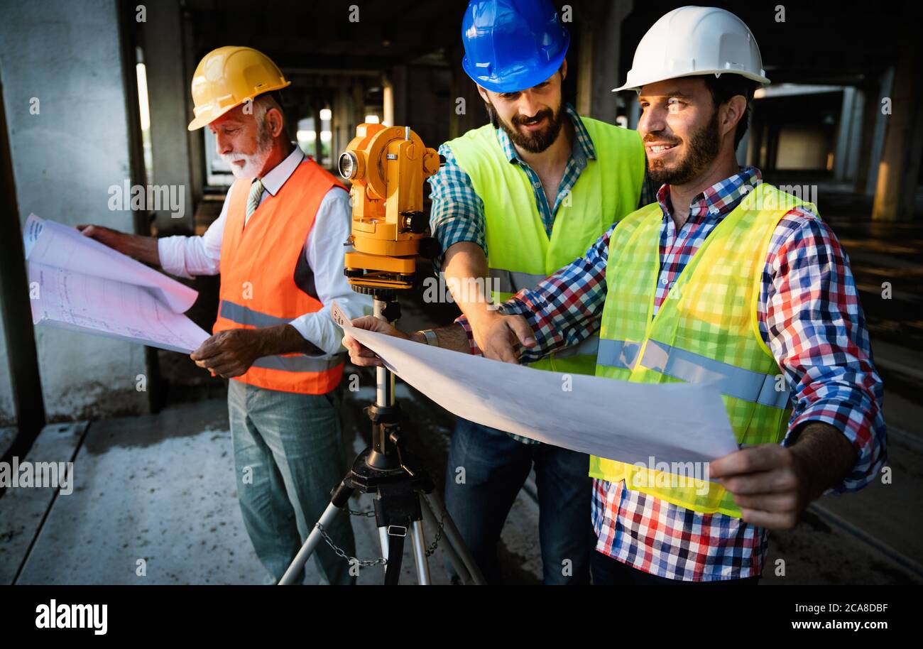 Two satisfied engineers talking at building site with construction ...