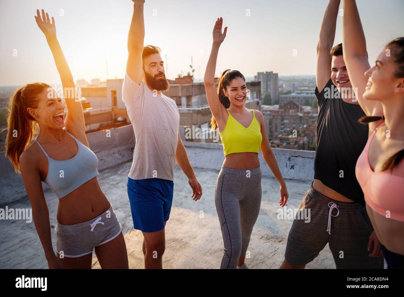 Portrait of smiling people doing power fitness exercise at yoga class ...