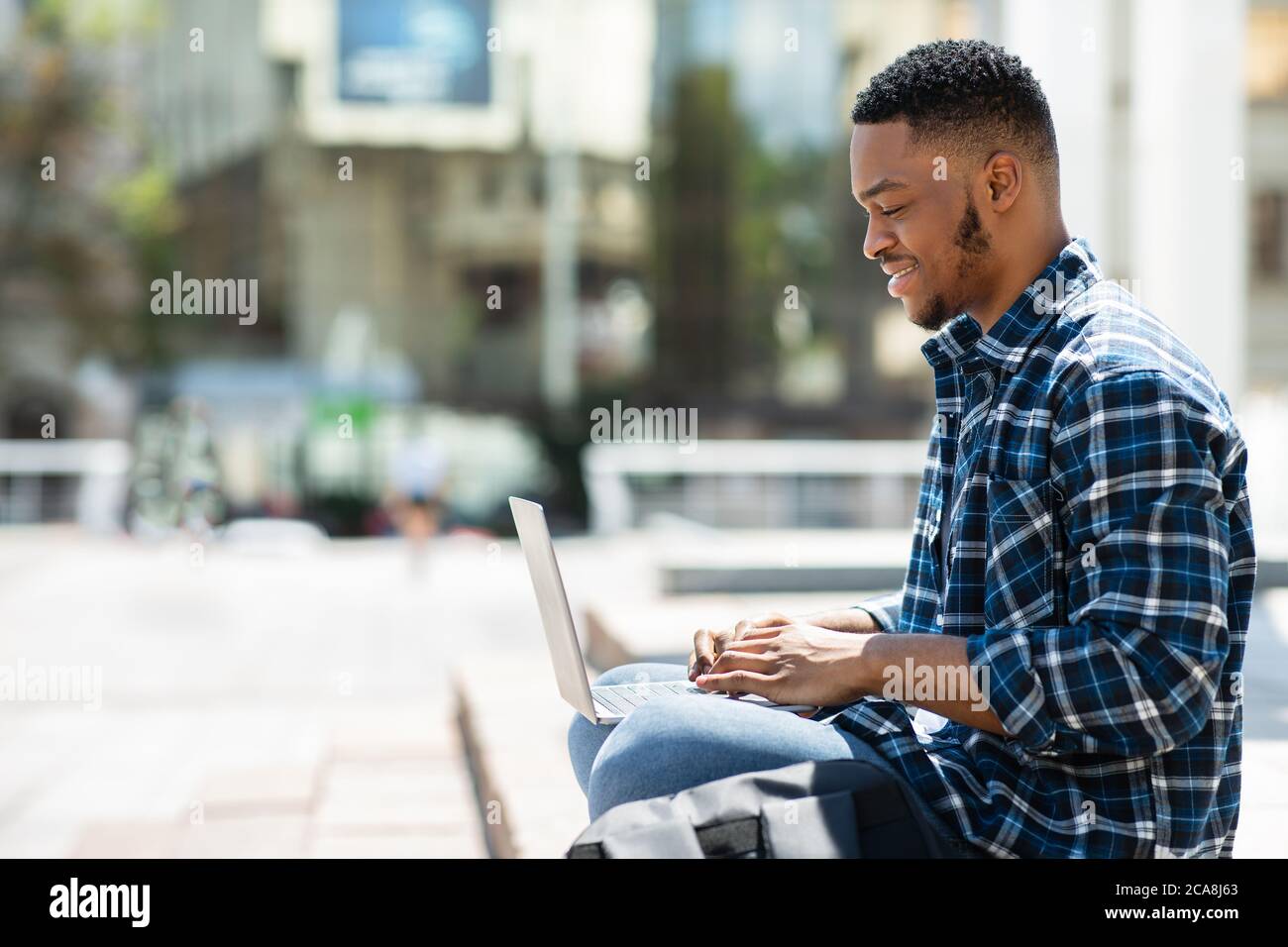 Glad black man using laptop, side view Stock Photo - Alamy Glad black man using laptop, side view Stock Photo - Alamy