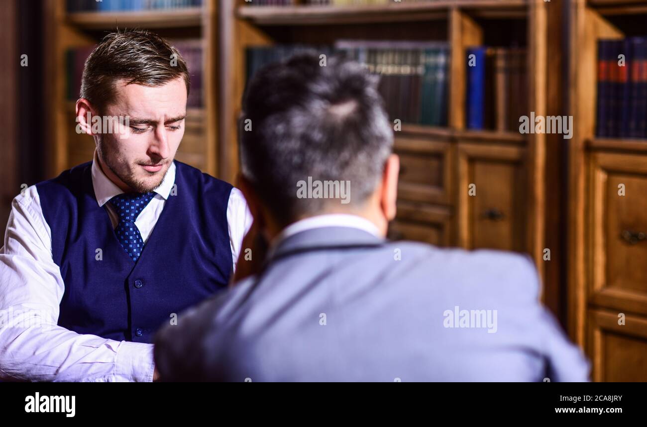 Men with antique bookshelves on background. Intelligent men, scientists ...