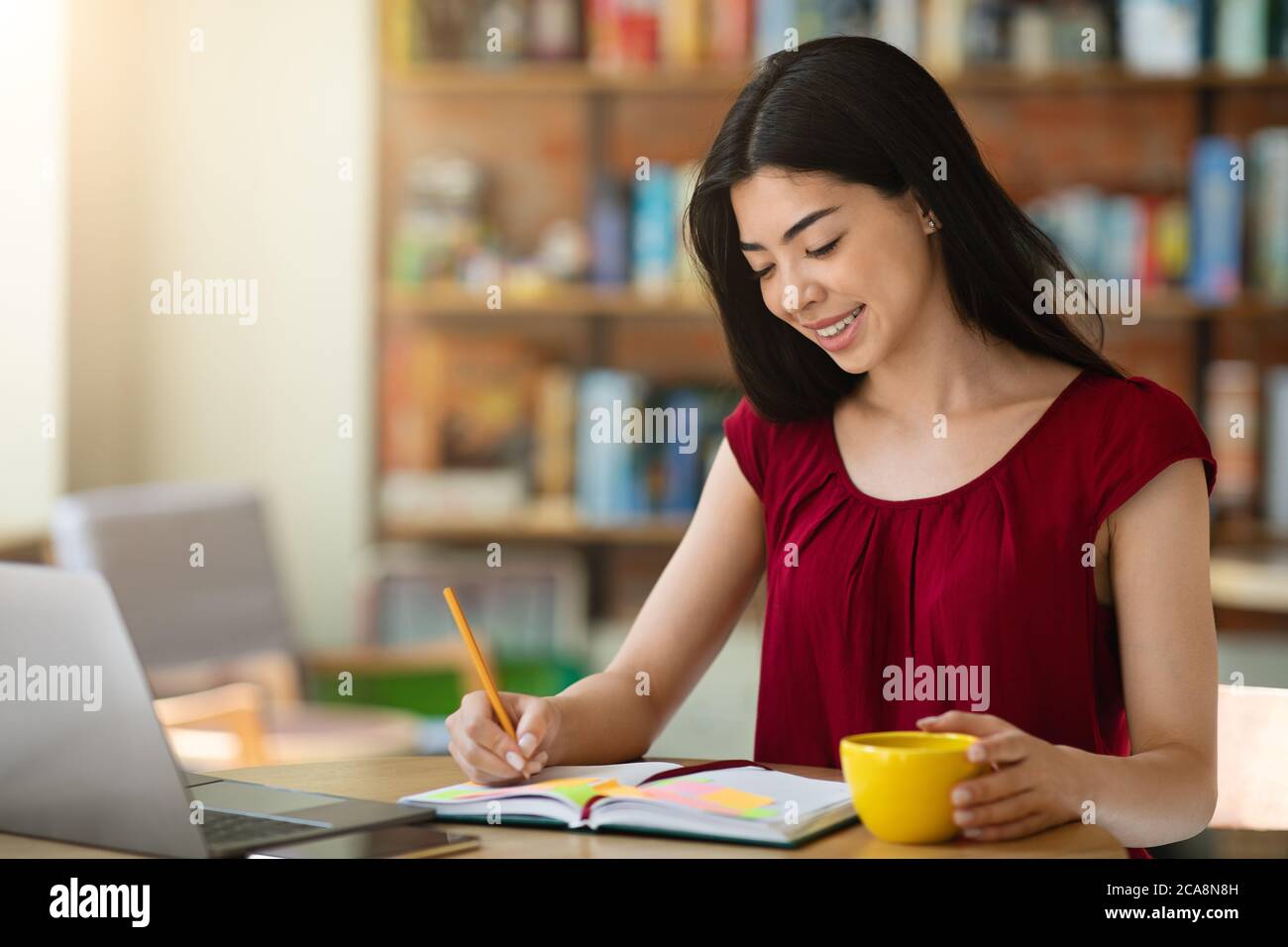 Asian girl personal assistant taking notes to notepad while working in ...