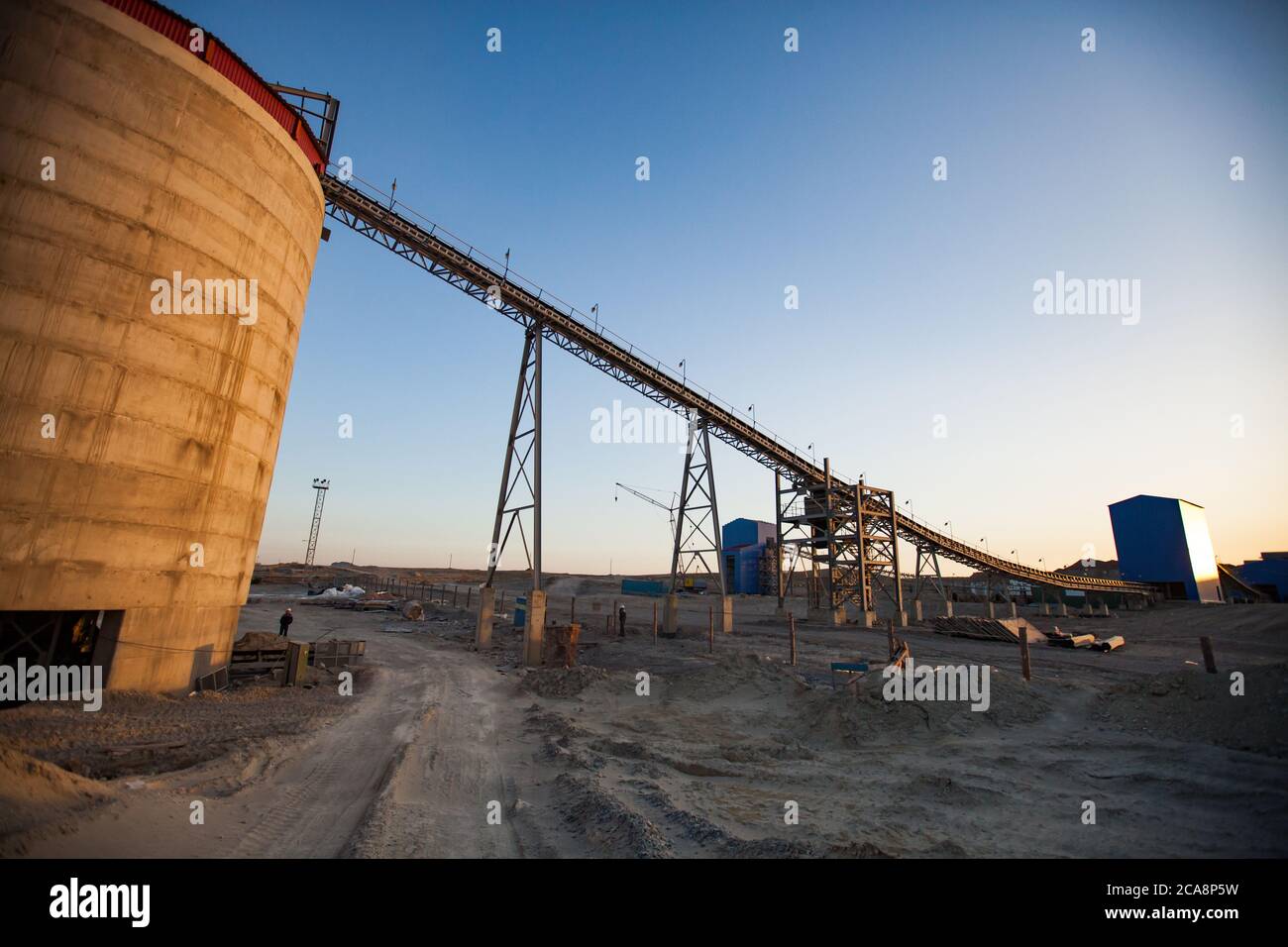 Gold mining and processing plant. Metal conveyor and concrete silo in ...