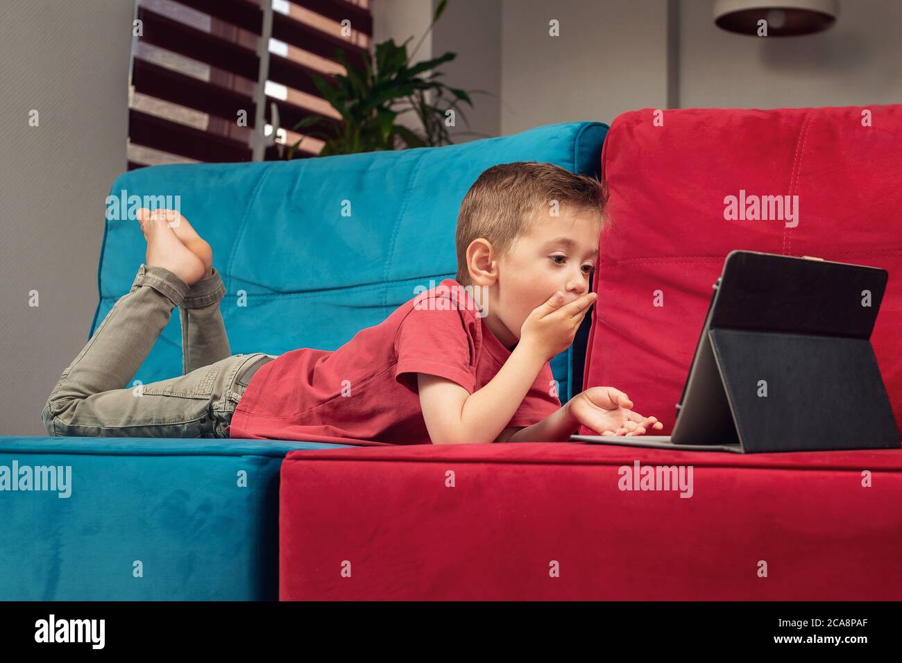 Emotional cute kid 4-5 years old, watching tablet Stock Photo - Alamy