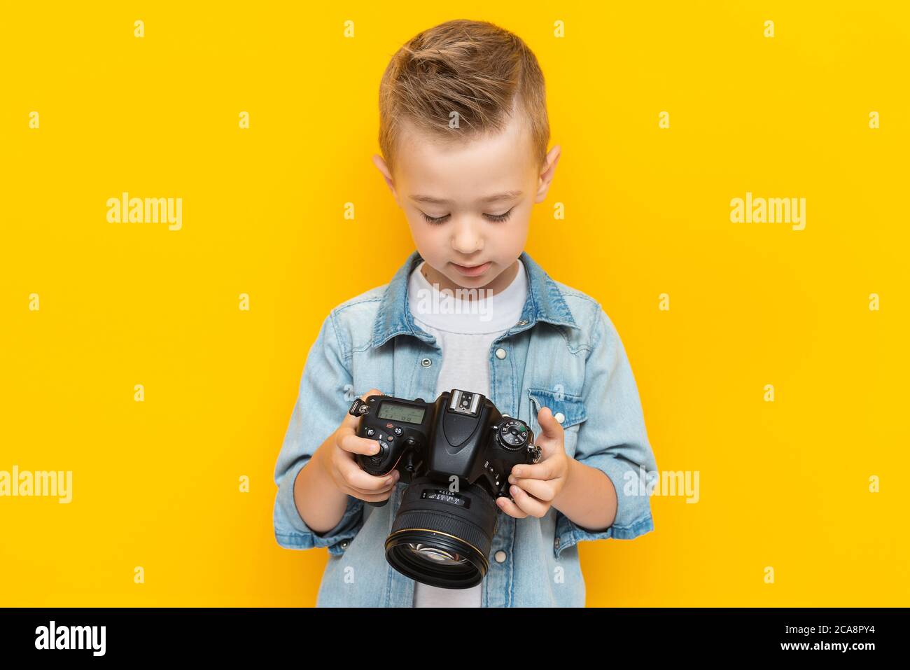 Happy little boy looks through photos on camera Stock Photo - Alamy