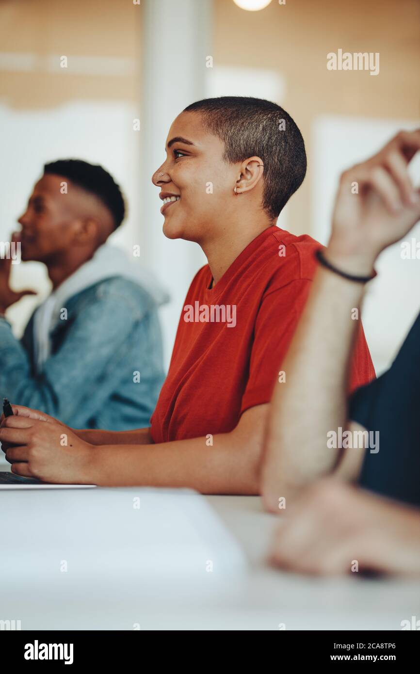 Smiling female student sitting in college classroom. Girl attending a ...