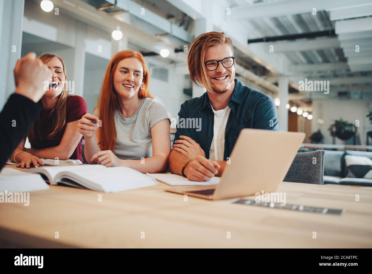Group of students studying in a library. Young people sitting together ...