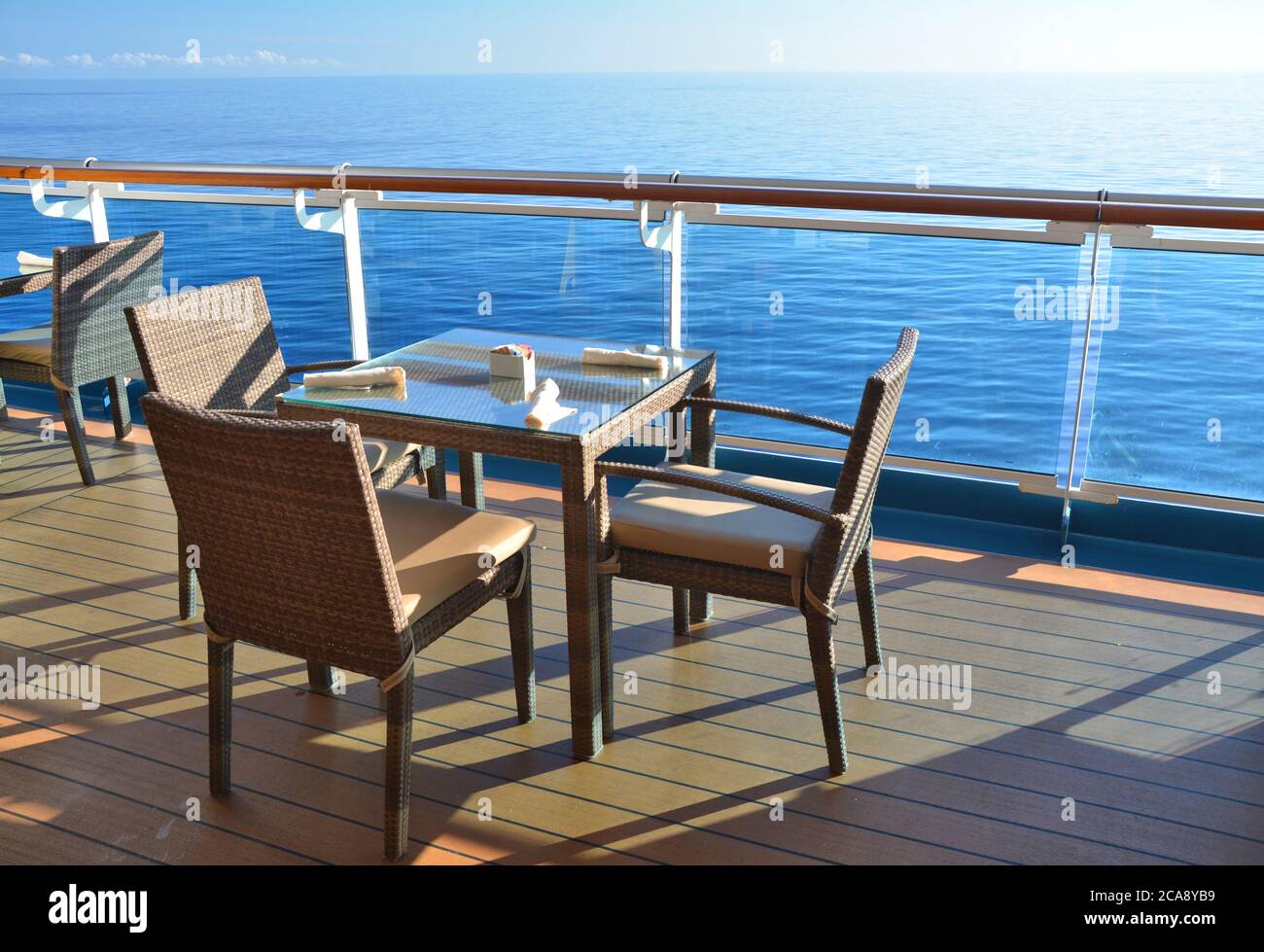 Restaurant tables on the open deck of cruise ship. Caribbean sea view ...