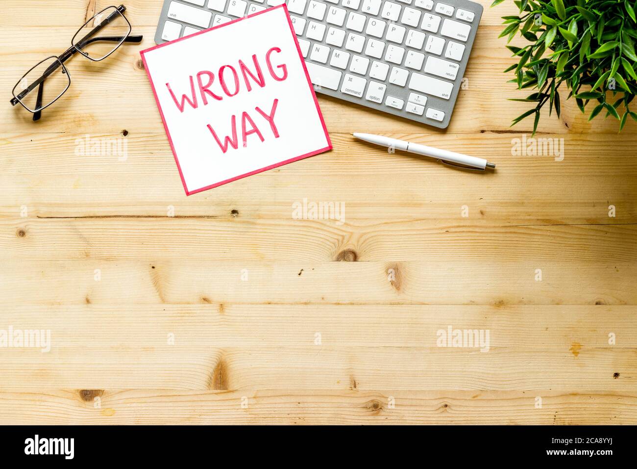 Business failure. Wrong way icon in hands on office desk top-down copy ...