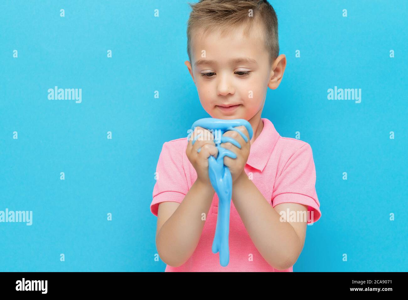 Funny boy playing with blue homemade slime Stock Photo - Alamy