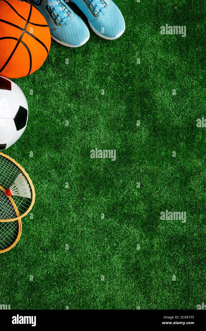 Sport balls and badminton rackets on football grass. Top view copy ...